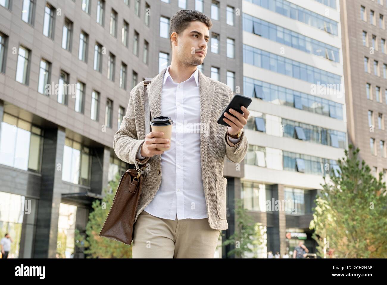 Attractive businessman walking holding hi-res stock photography and ...