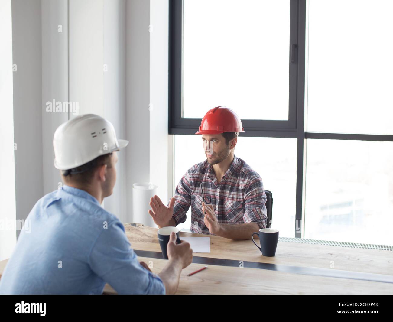handsome construction worker is asking his co-worker to calm down ...