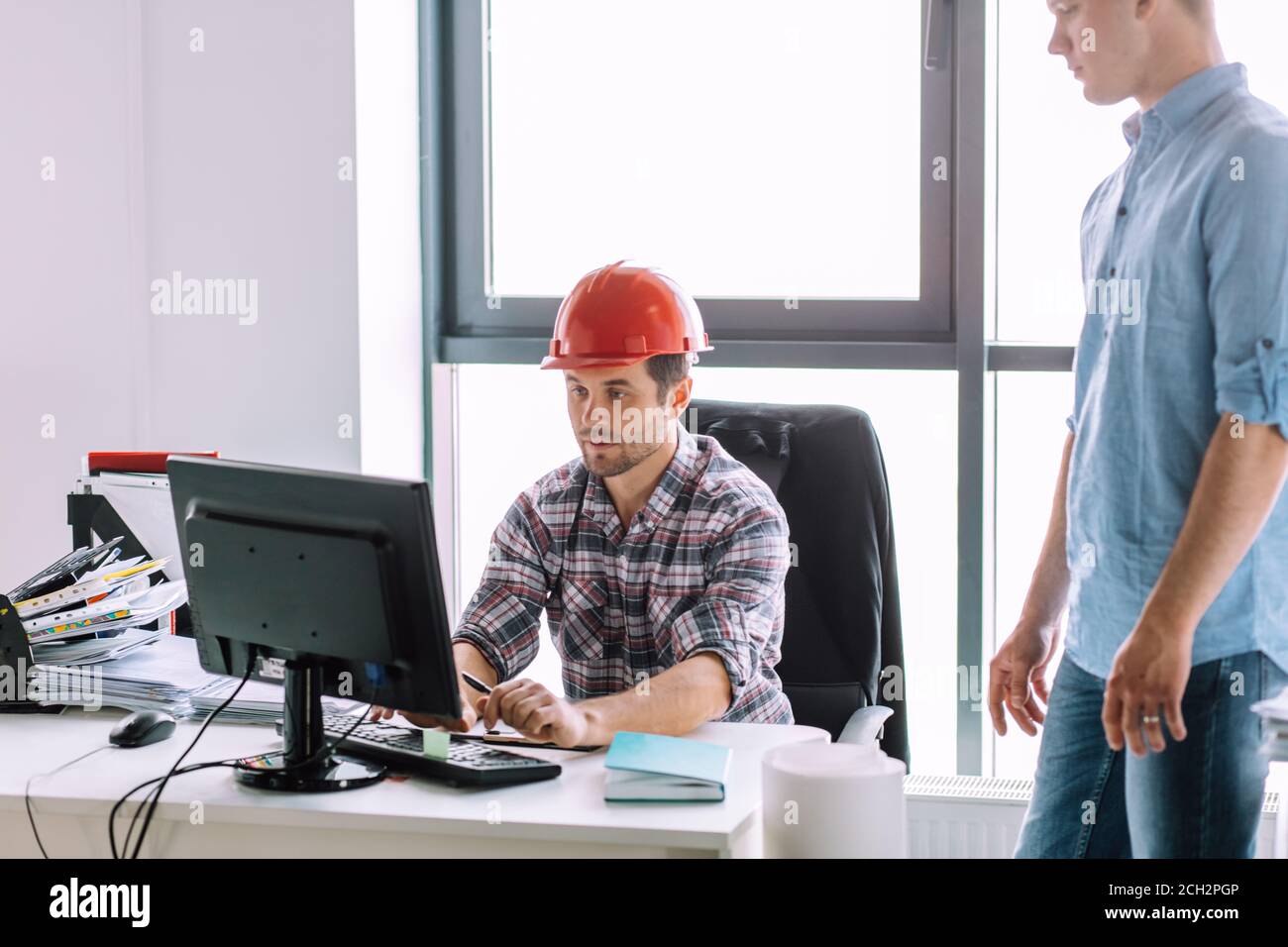 serious handsome engineer is working with computer indoors. computer ...