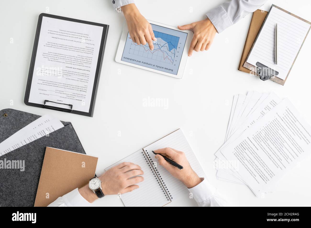 Flat layout of hands of two young managers or brokers analyzing online ...