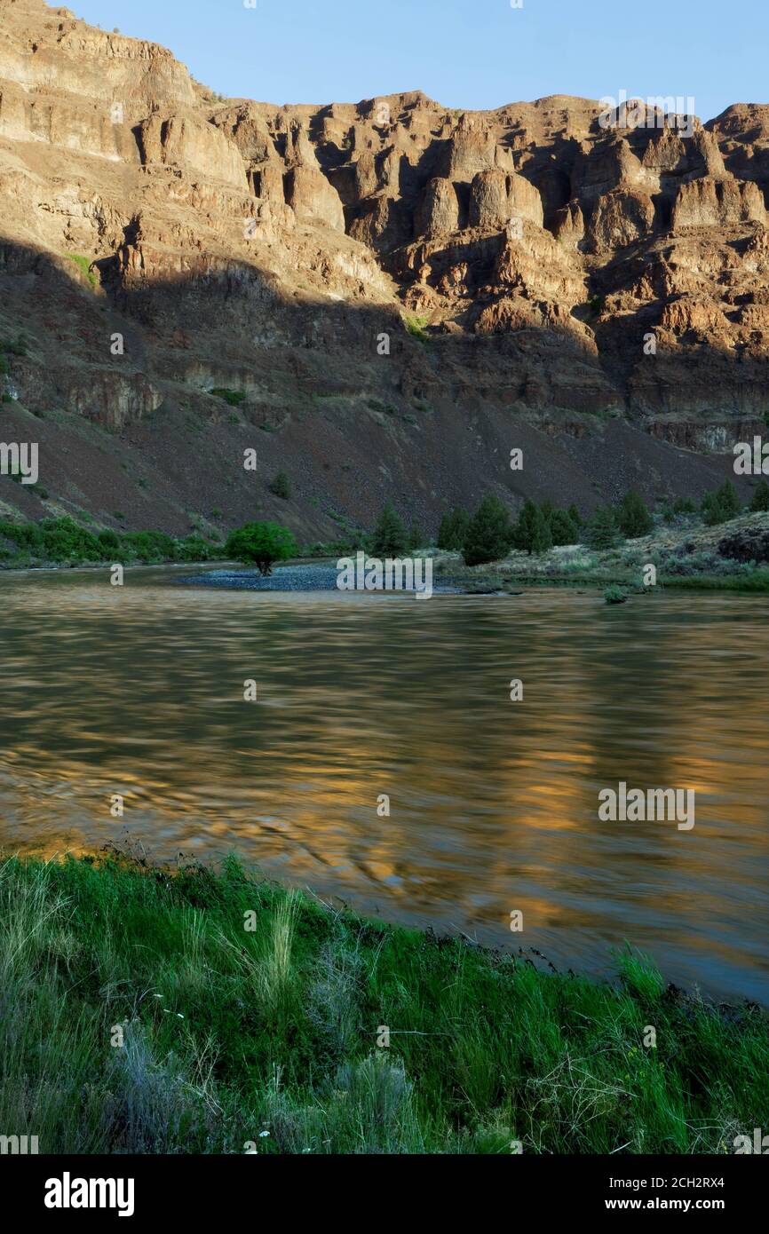 Basalt cliffs reflected on John Day River at sunrise, central Oregon ...