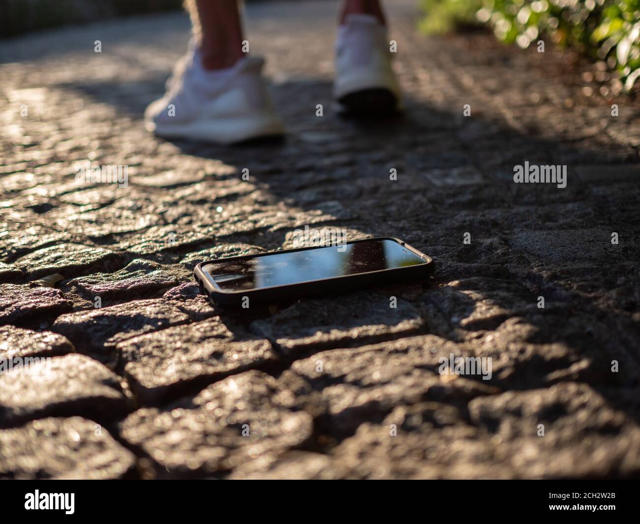 A man walking away after losing his phone on the sidewalk Stock Photo ...