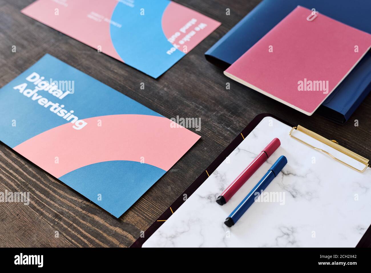 Two highlighters on paper in clipboard surrounded by brochures and ...