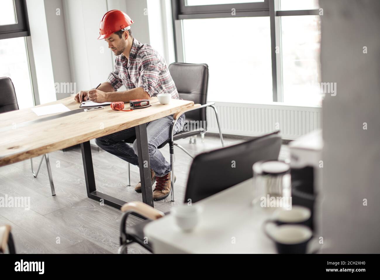 handsome constructor is estimating costs for building activities at ...