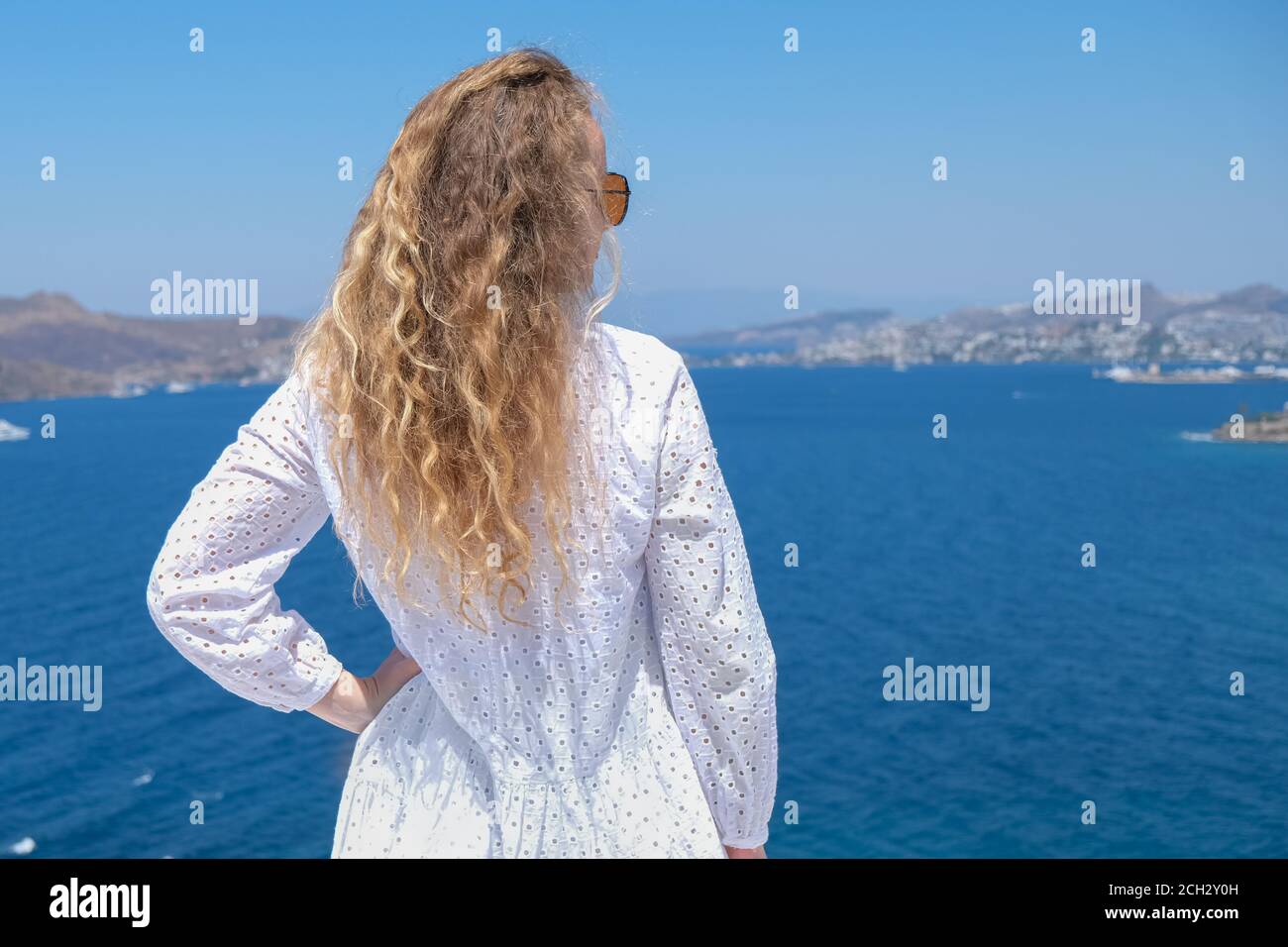 Beautiful woman from back in white dress sunglasses on white terrace of ...