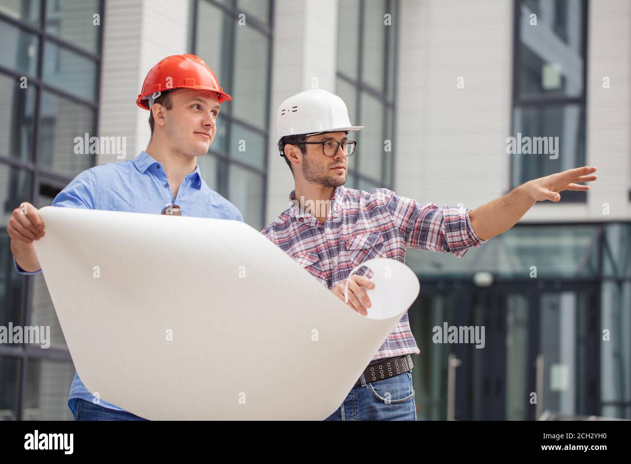 two builders are looking the area where the construction will be ...