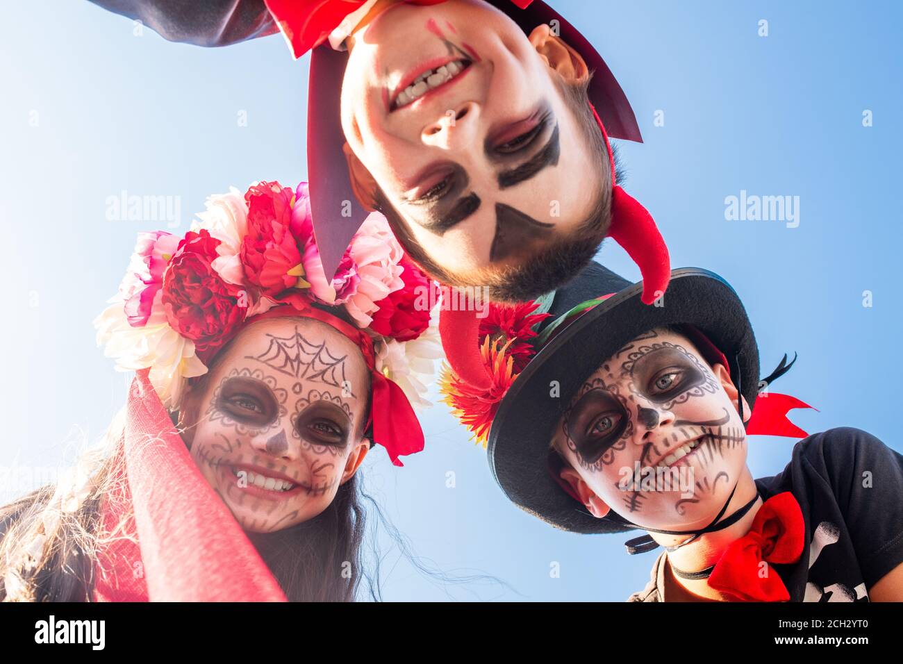 Three happy halloween children with painted faces standing in front of ...