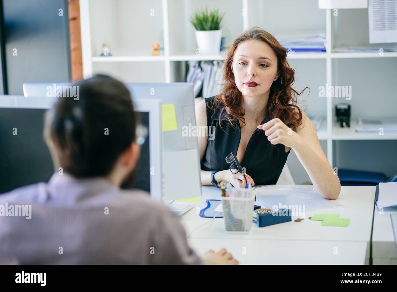 close up photo of two web-designers sitting at the computers opposite ...