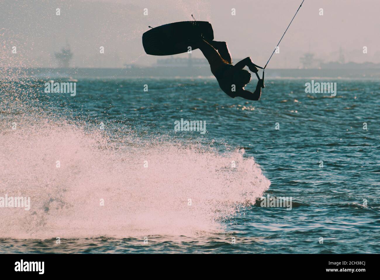 WAKEBOARDING AT THE SEA JUMPING HIGH DOING A BACKFLIP Stock Photo - Alamy