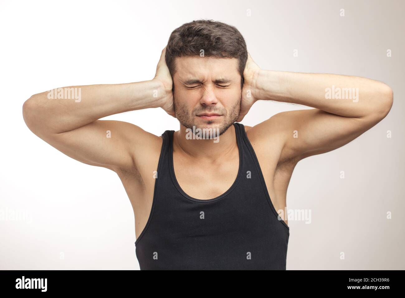 pleasant guy with closed eyes trying not to hear the noise. man hates ...