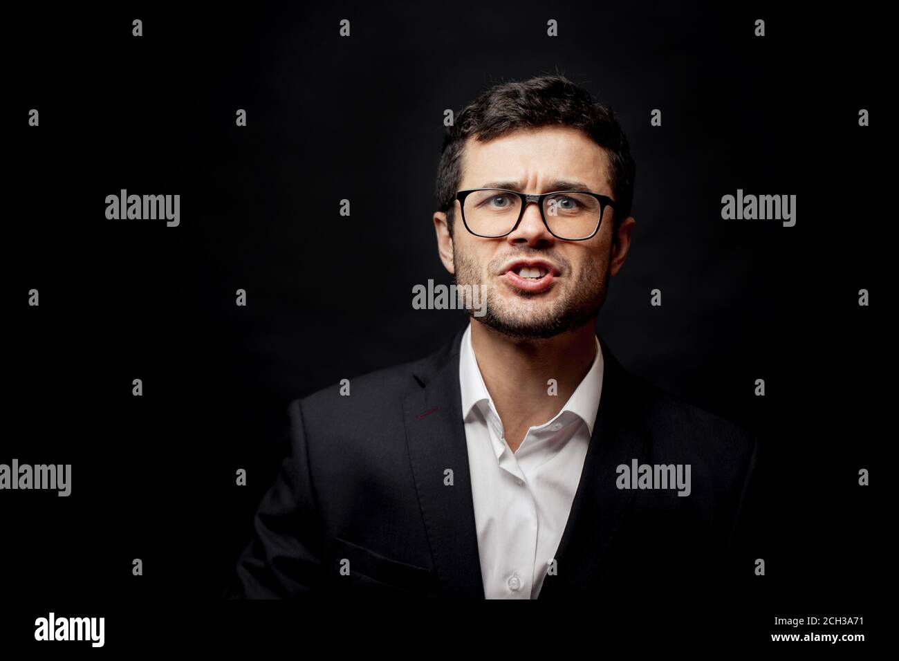 frustrated business man shouting at somebody at black background Stock ...