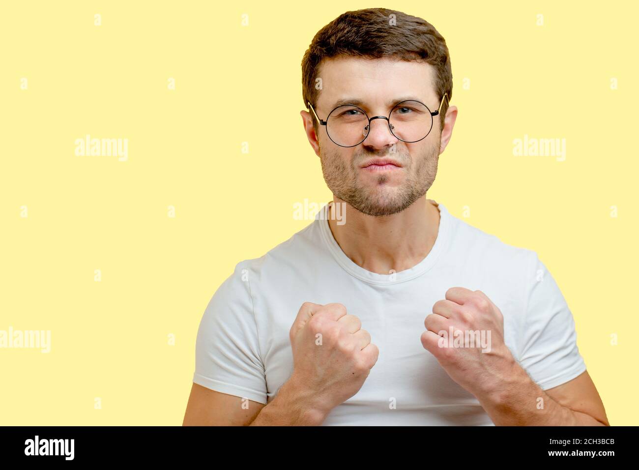 close up portrait of young mad man with clenched fists. violent guy in ...
