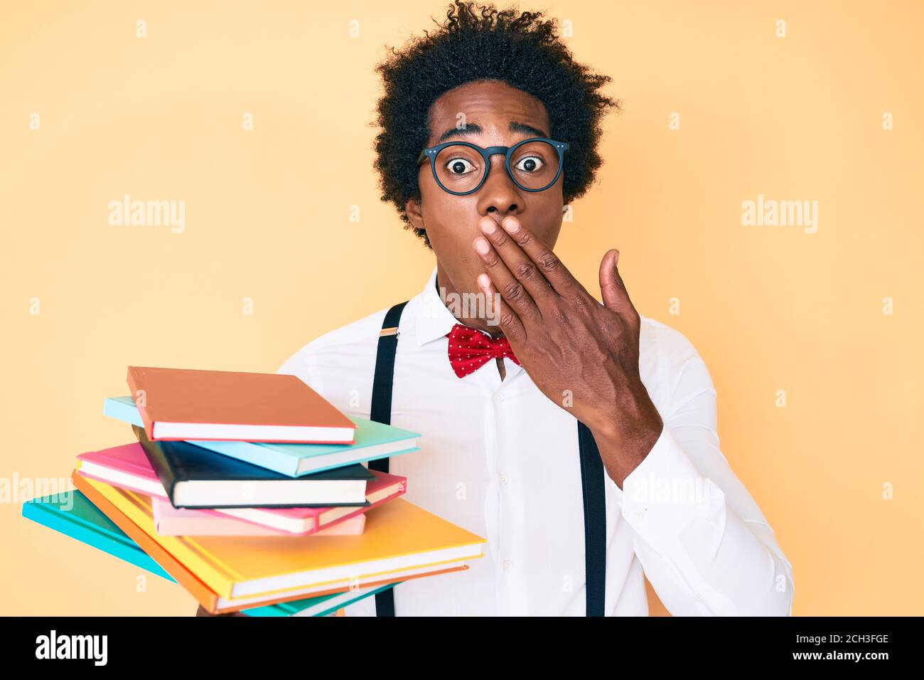 Handsome african american nerd man with afro hair holding books ...