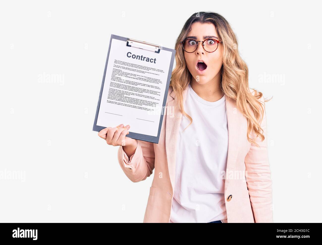Young caucasian woman holding clipboard with contract document scared ...