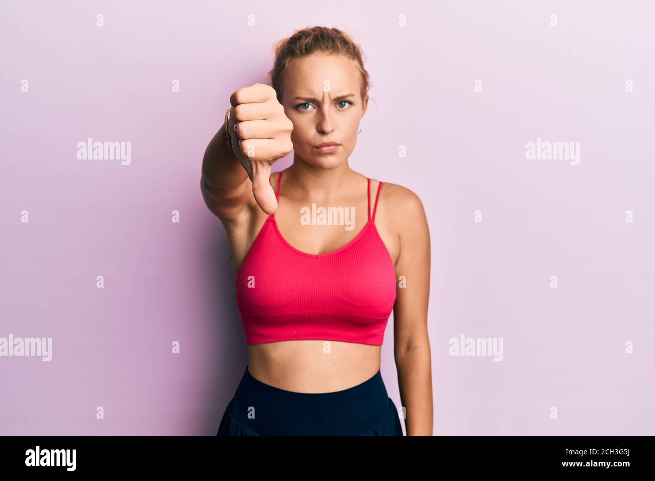 Beautiful caucasian woman wearing sportswear looking unhappy and angry ...