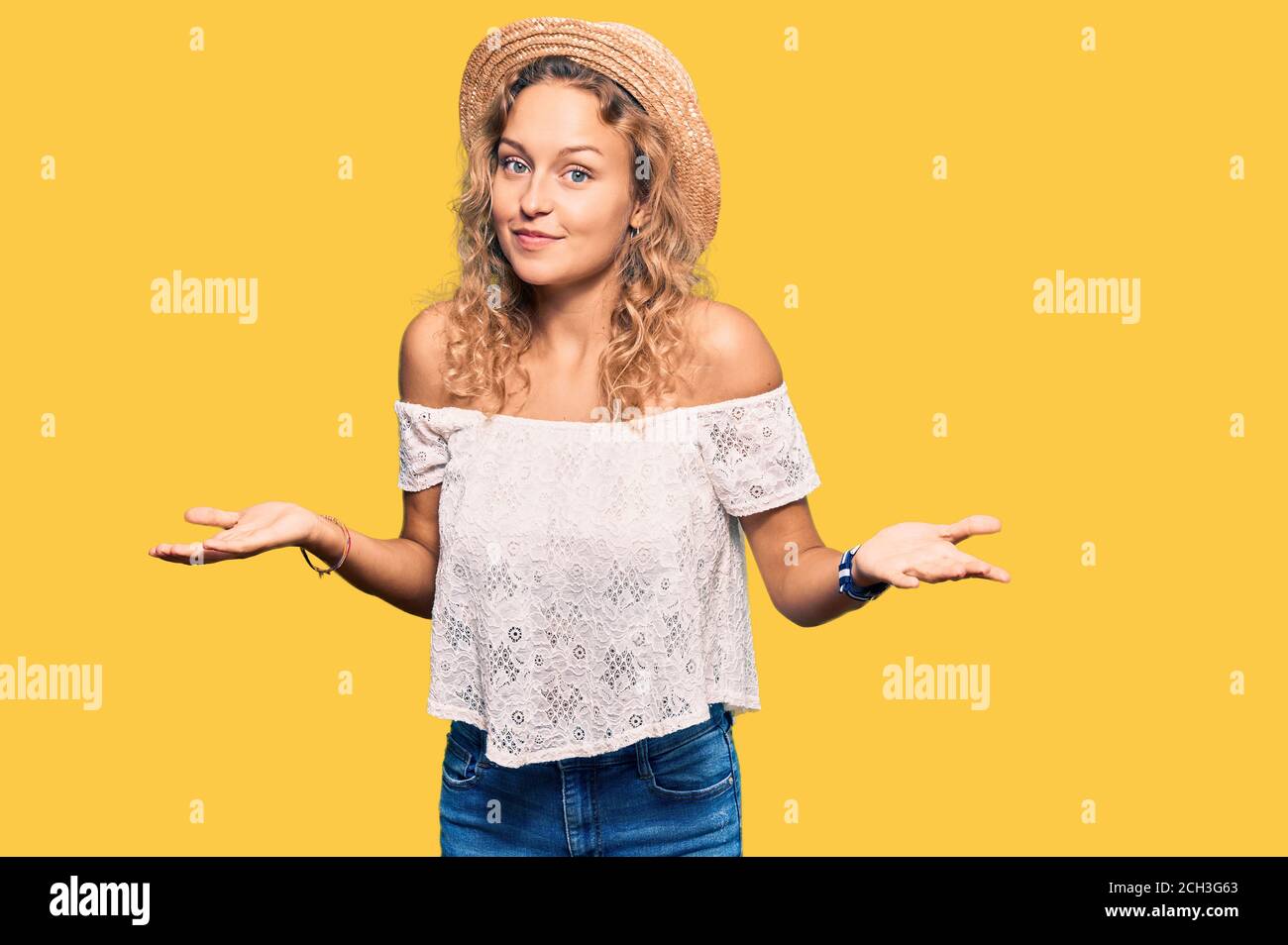 Beautiful caucasian woman wearing summer hat clueless and confused ...