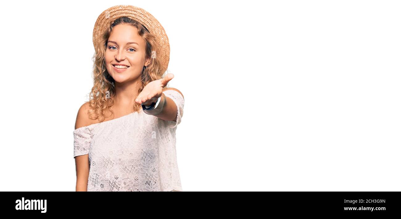 Beautiful caucasian woman wearing summer hat smiling friendly offering ...