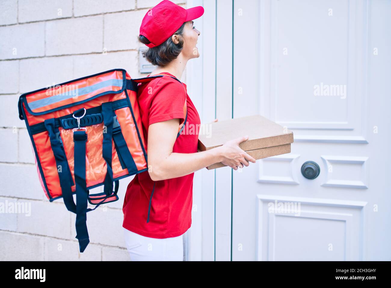 Delivery business worker woman wearing uniform smiling happy knocking ...