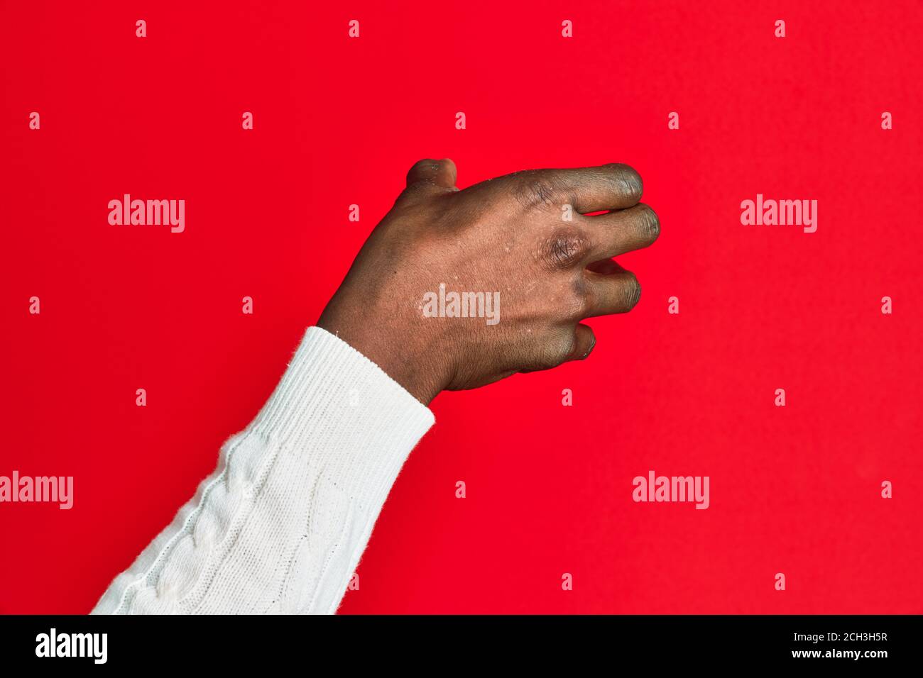 Arm and hand of african american black young man over red isolated ...