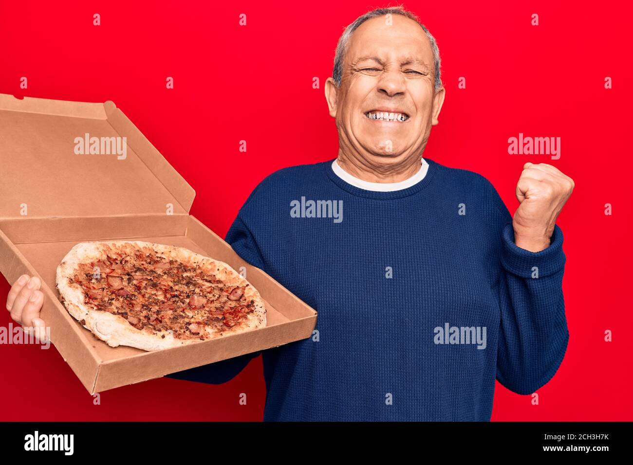 Senior man with grey hair holding delivery cardboard of italian pizza ...
