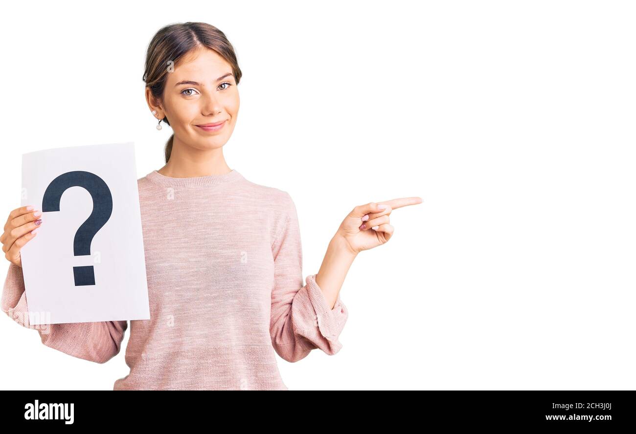Beautiful caucasian woman with blonde hair holding question mark ...