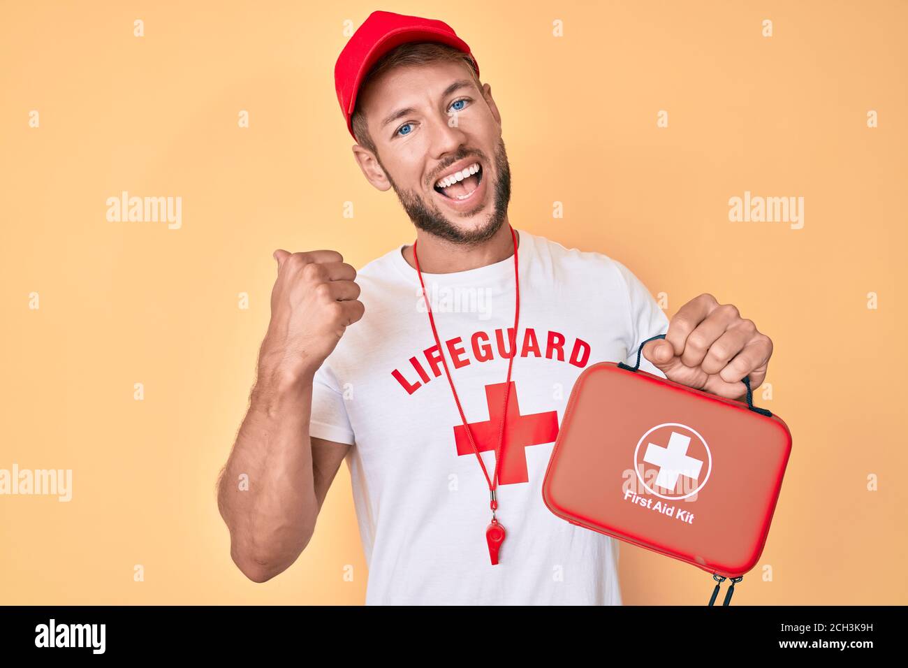Young caucasian man wearing lifeguard t shirt holding first aid kit ...