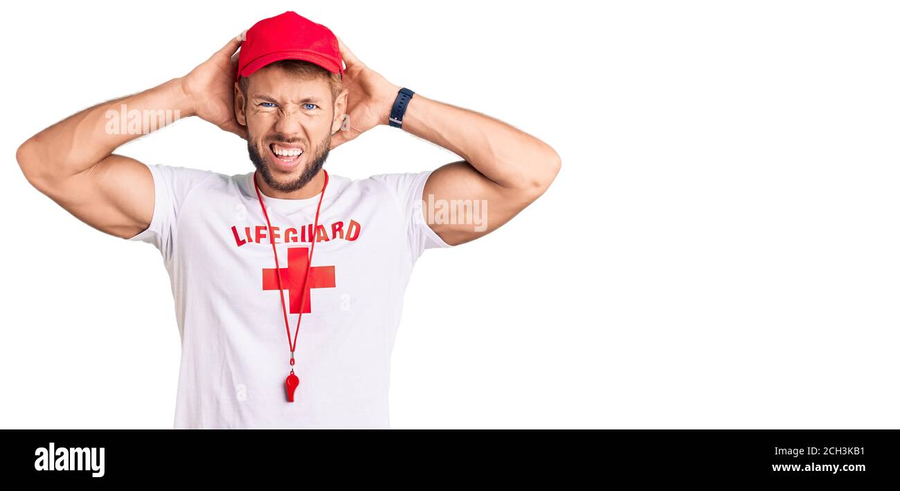 Young caucasian man wearing lifeguard t shirt holding whistle crazy and ...