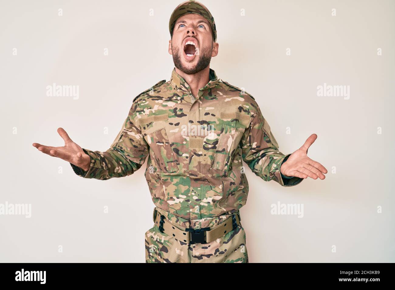 Young caucasian man wearing camouflage army uniform crazy and mad ...