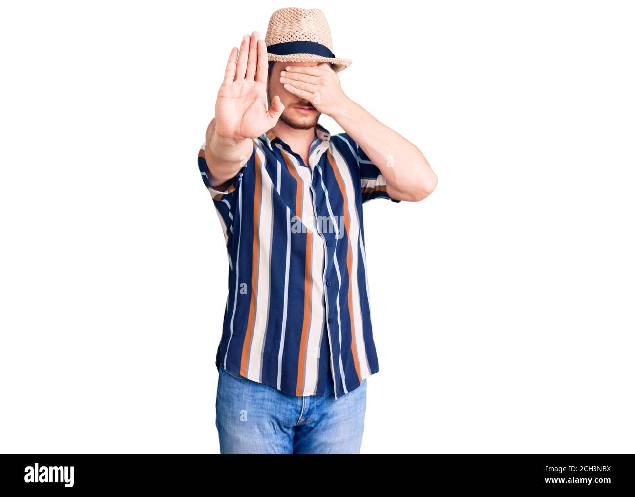 Young handsome caucasian man wearing summer hat covering eyes with ...