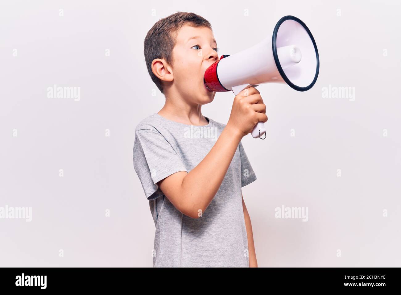 Adorable caucasian kid boy with angry expression. Screaming loud using ...