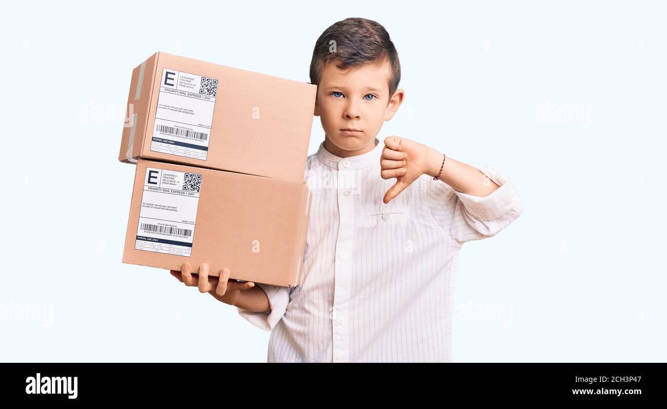 Cute blond kid holding delivery package with angry face, negative sign ...