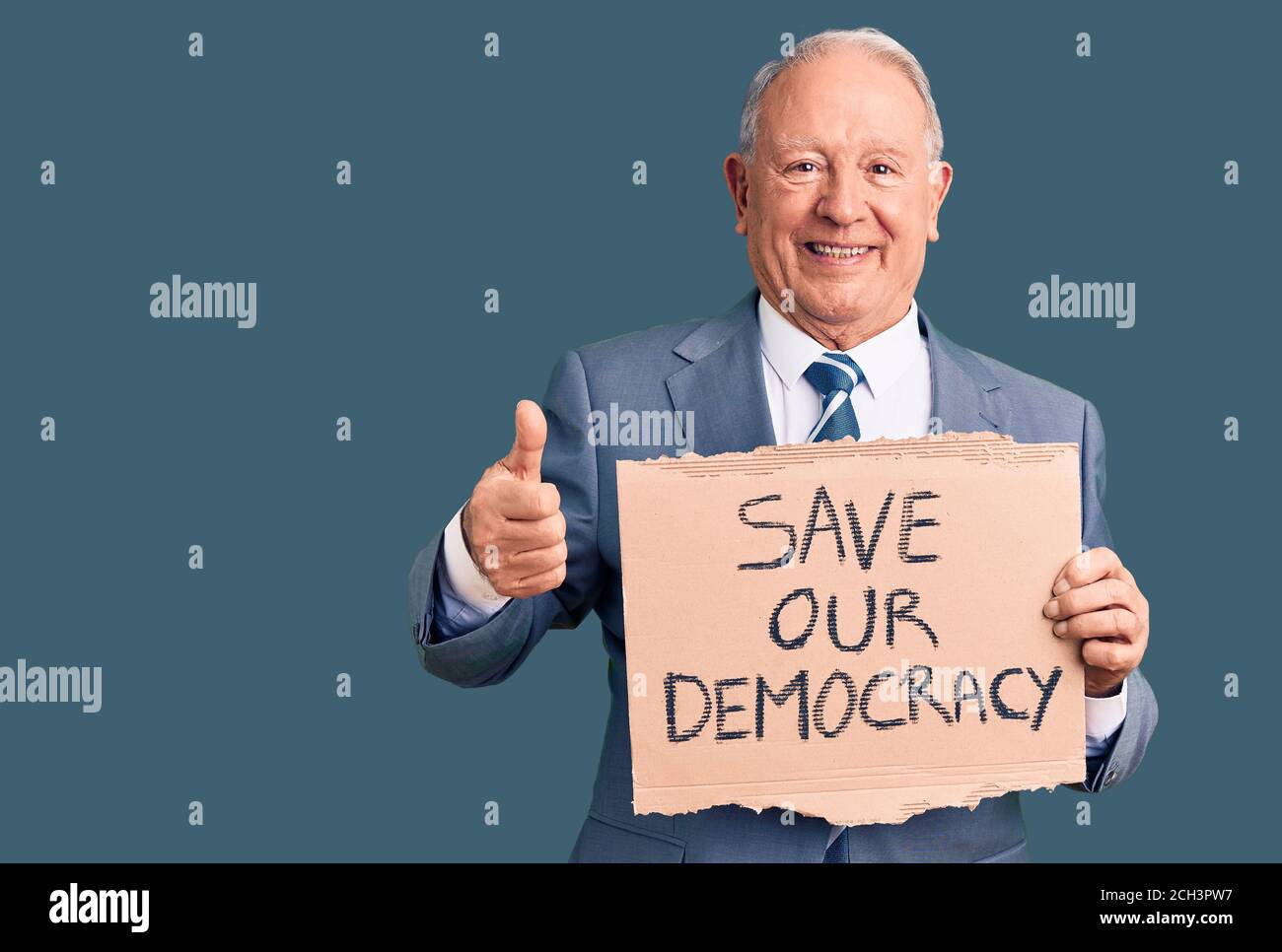 Senior handsome grey-haired man holding save our democracy cardboard ...