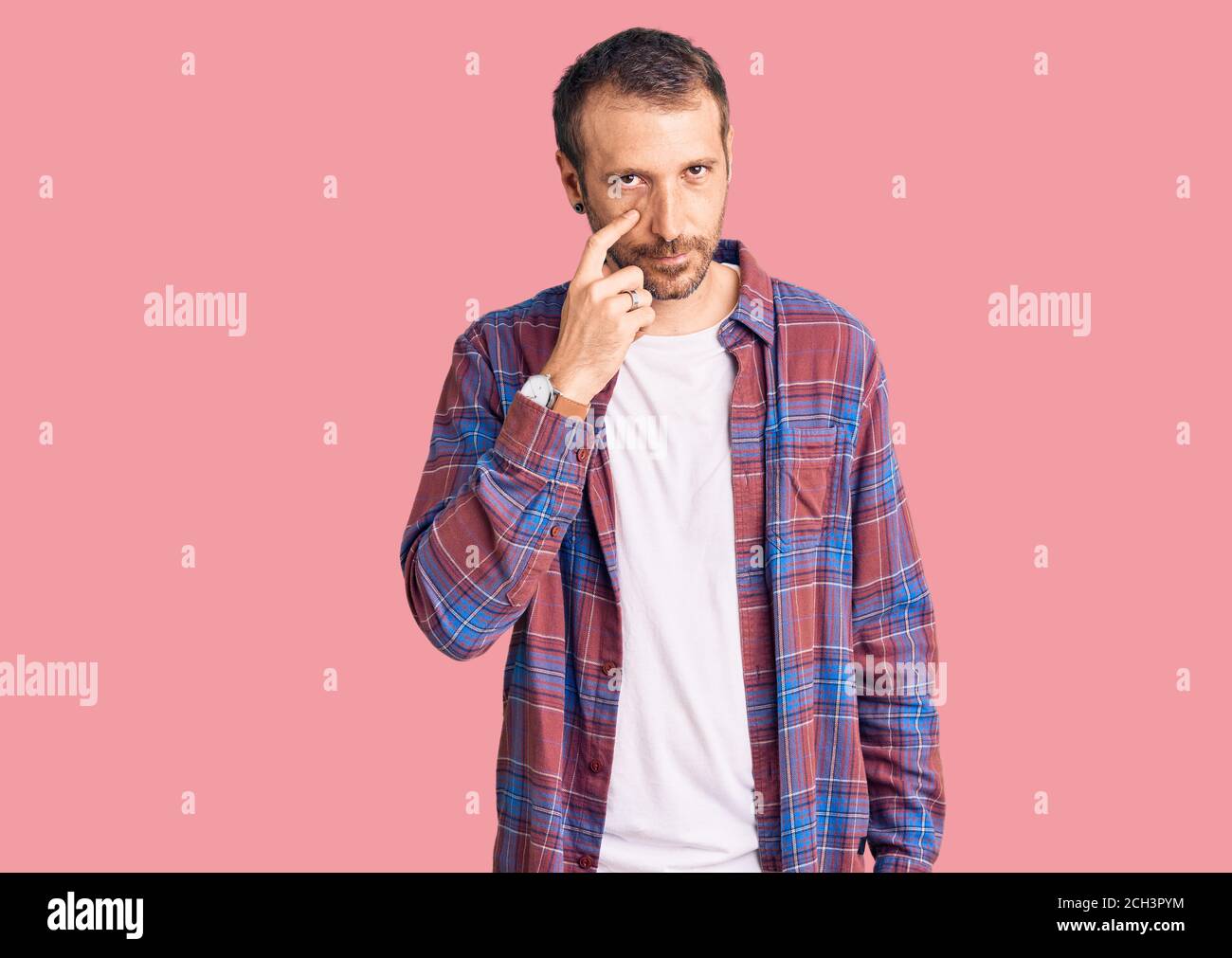Young handsome man wearing casual clothes pointing to the eye watching ...