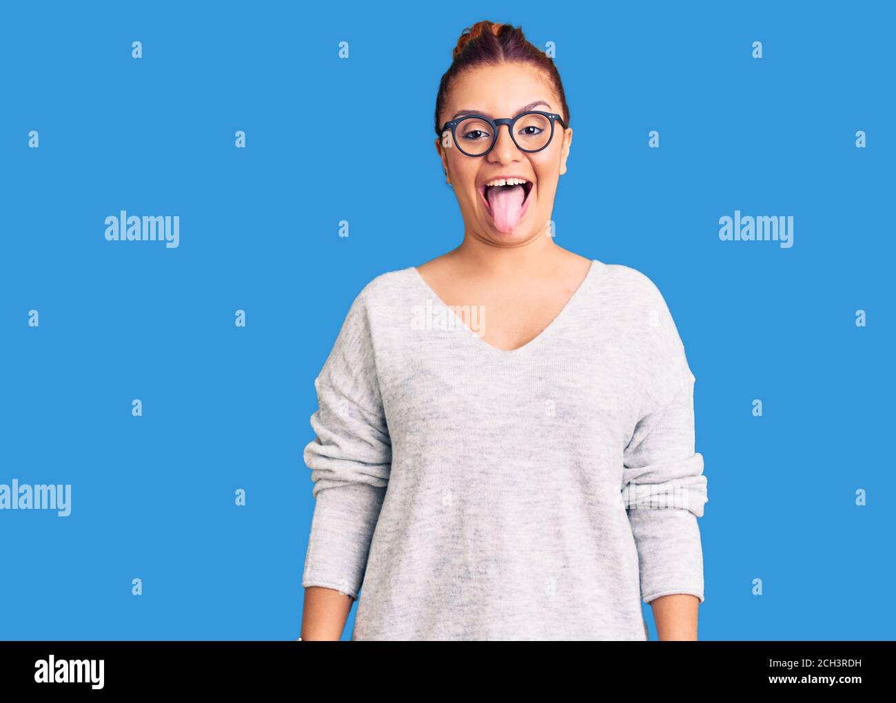 Young latin woman wearing casual clothes sticking tongue out happy with ...