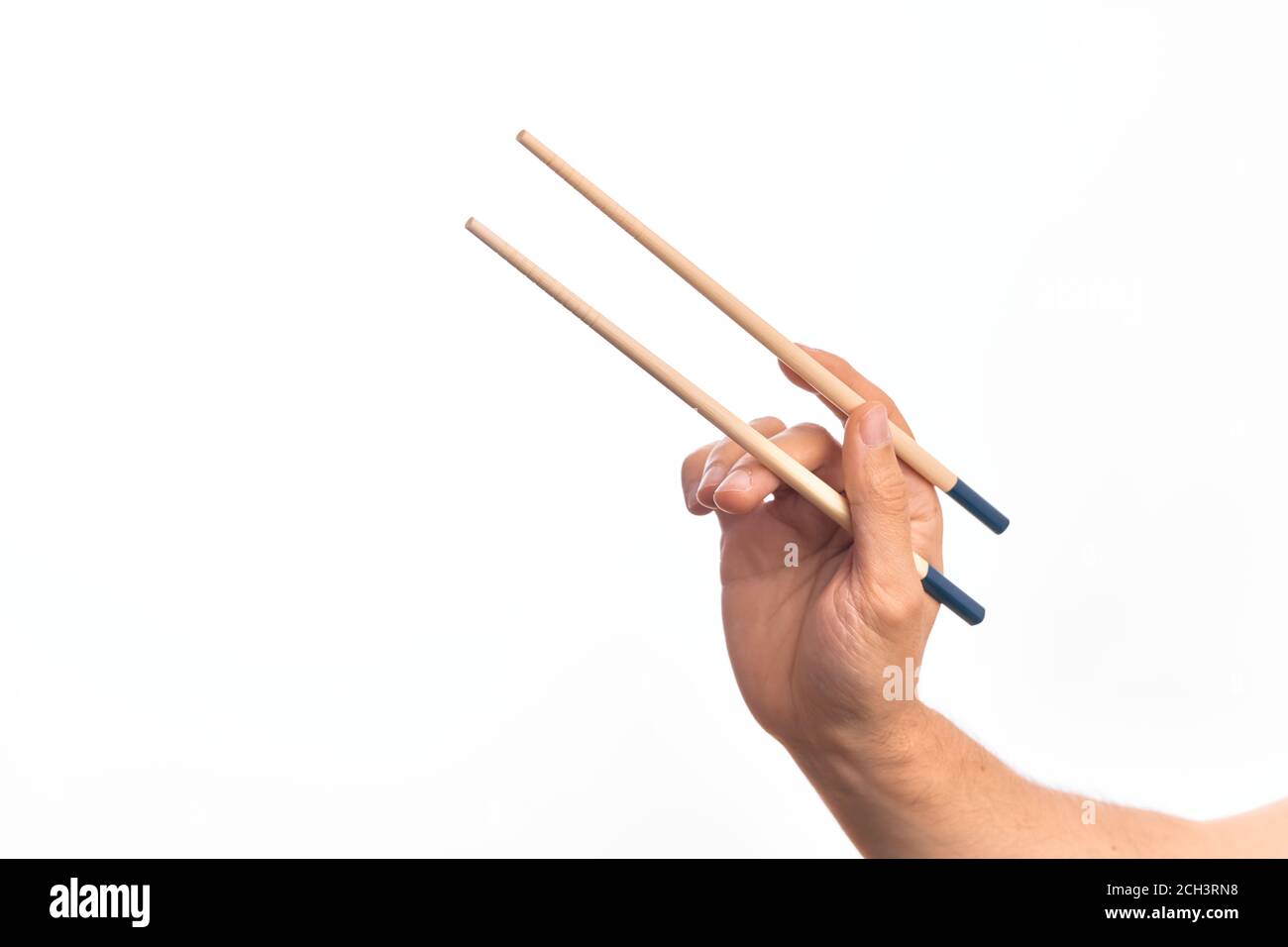 Hand of caucasian young man holding chopsticks over isolated white ...