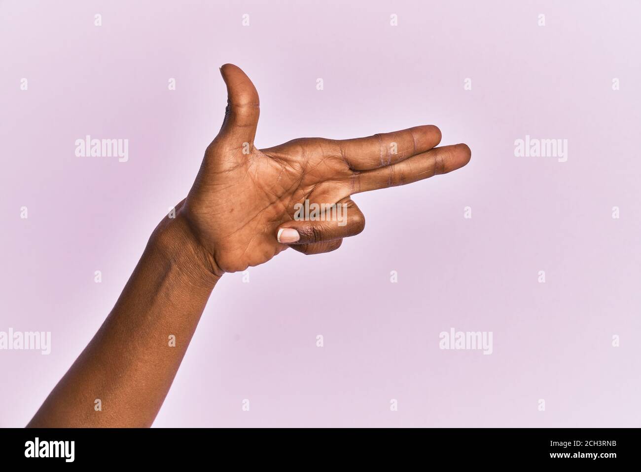 Arm and hand of black middle age woman over pink isolated background ...