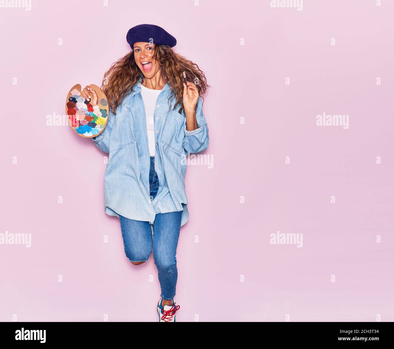 Young beautiful curly artist woman with tattoo wearing french beret ...