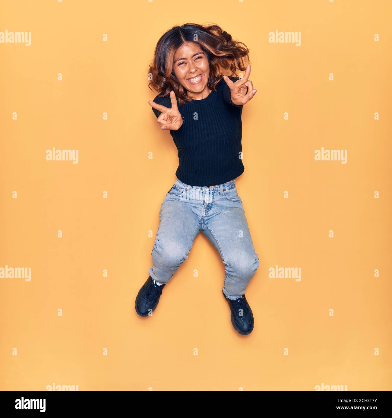 Young beautiful latin woman smiling happy. Jumping with smile on face ...