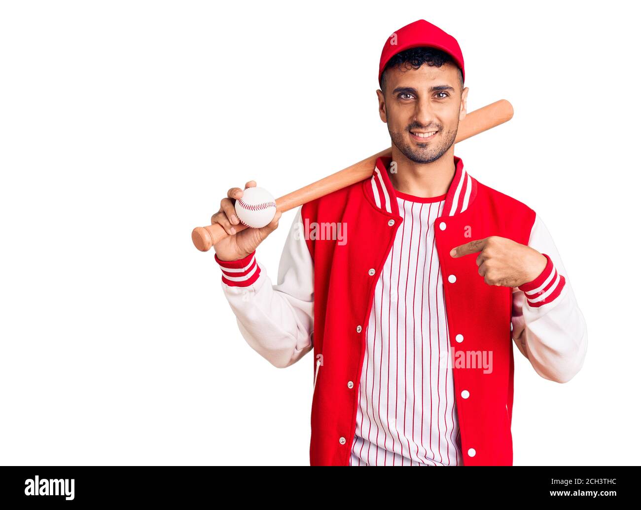 Young hispanic man playing baseball holding bat and ball pointing ...