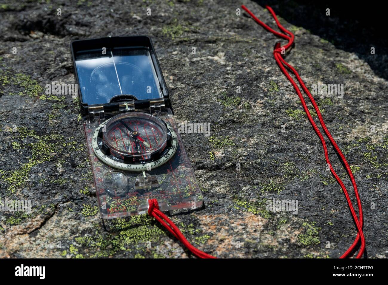 Modern compass for navigating in mountains placed on rocks Stock Photo ...