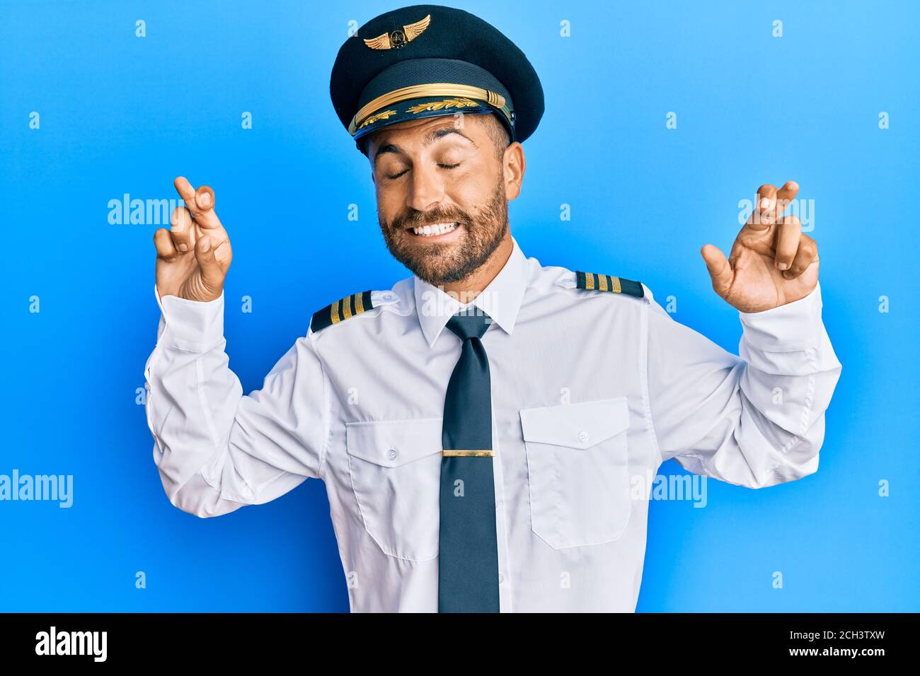 Handsome man with beard wearing airplane pilot uniform gesturing finger ...