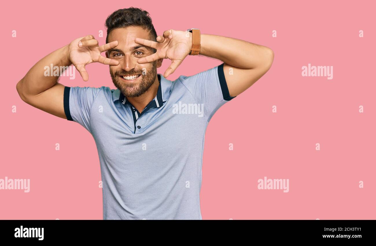 Handsome man with beard wearing casual clothes doing peace symbol with ...