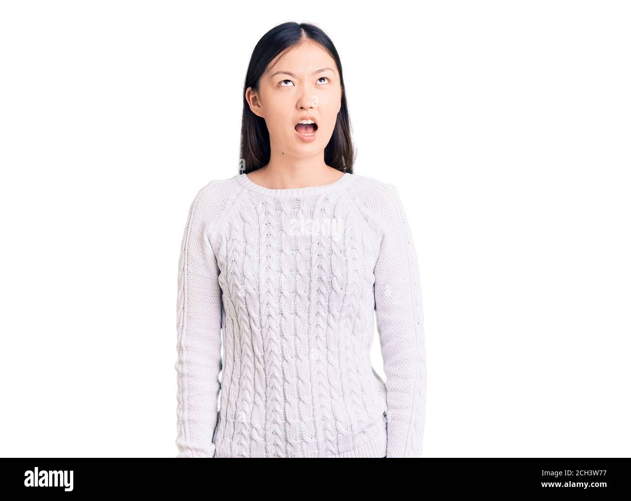 Young beautiful chinese woman wearing casual sweater angry and mad ...