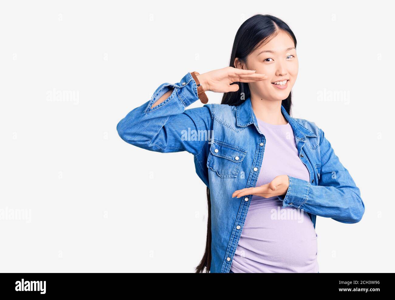 Young beautiful chinese woman pregnant expecting baby gesturing with ...