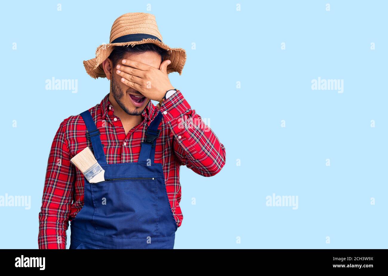 Handsome latin american young man weaing handyman uniform smiling and ...