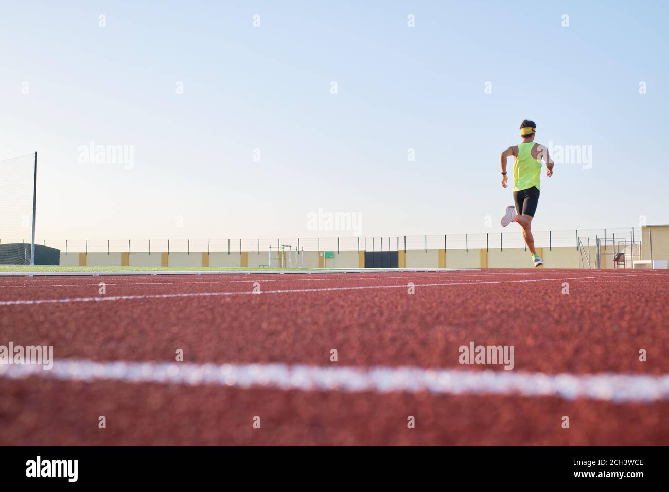 young man trains running on new and red tracks Stock Photo - Alamy