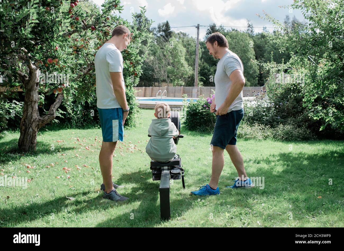 two men working out with their son at home in a home gym Stock Photo ...