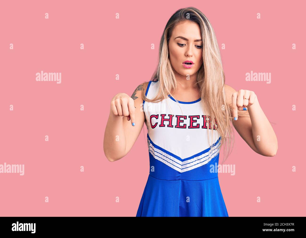 Young Beautiful Blonde Woman Wearing Cheerleader Uniform Pointing Down With Fingers Showing