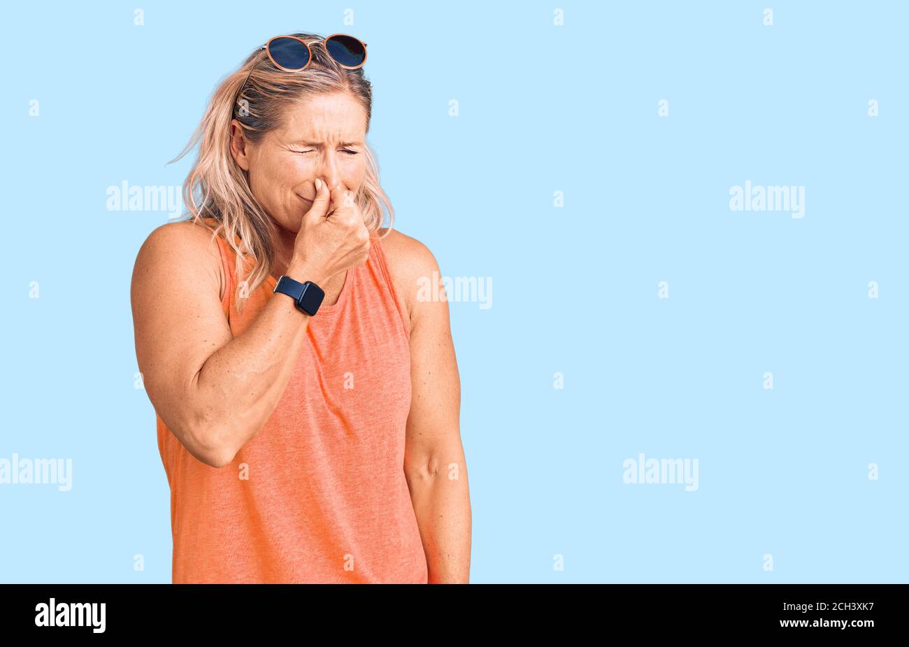 Middle age fit blonde woman wearing casual summer clothes and ...