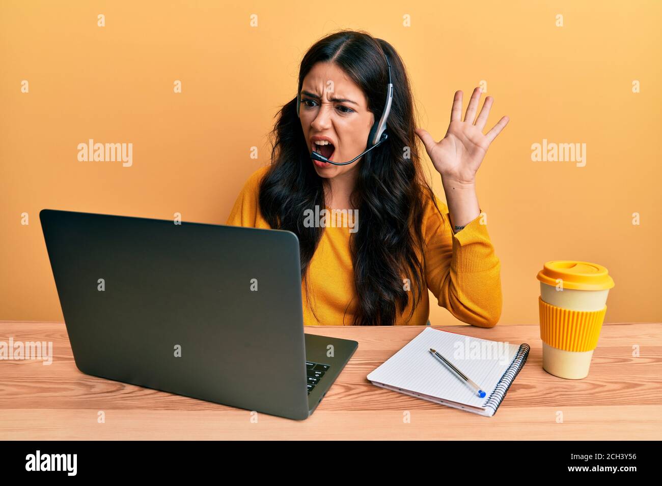 Beautiful brunette young woman wearing call center agent headset angry ...